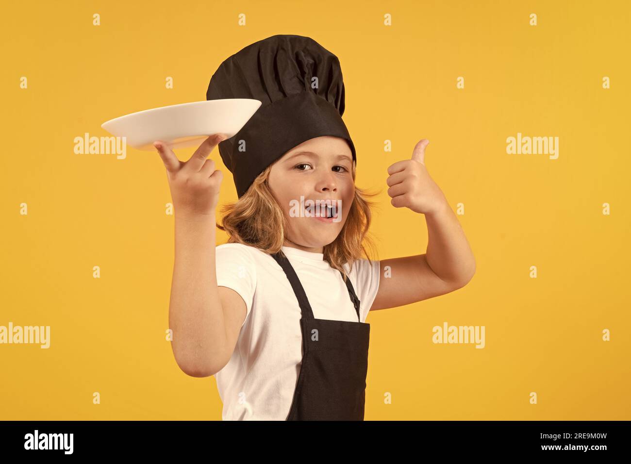 Funny child cook with cooking plate. Kid chef cook prepares food on ...