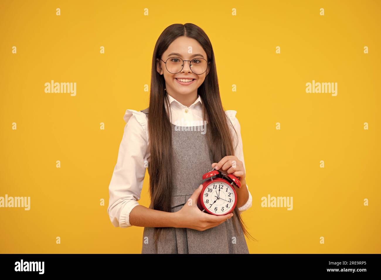 Portrait of teenage girl with clock alrm, time and deadline. Studio ...