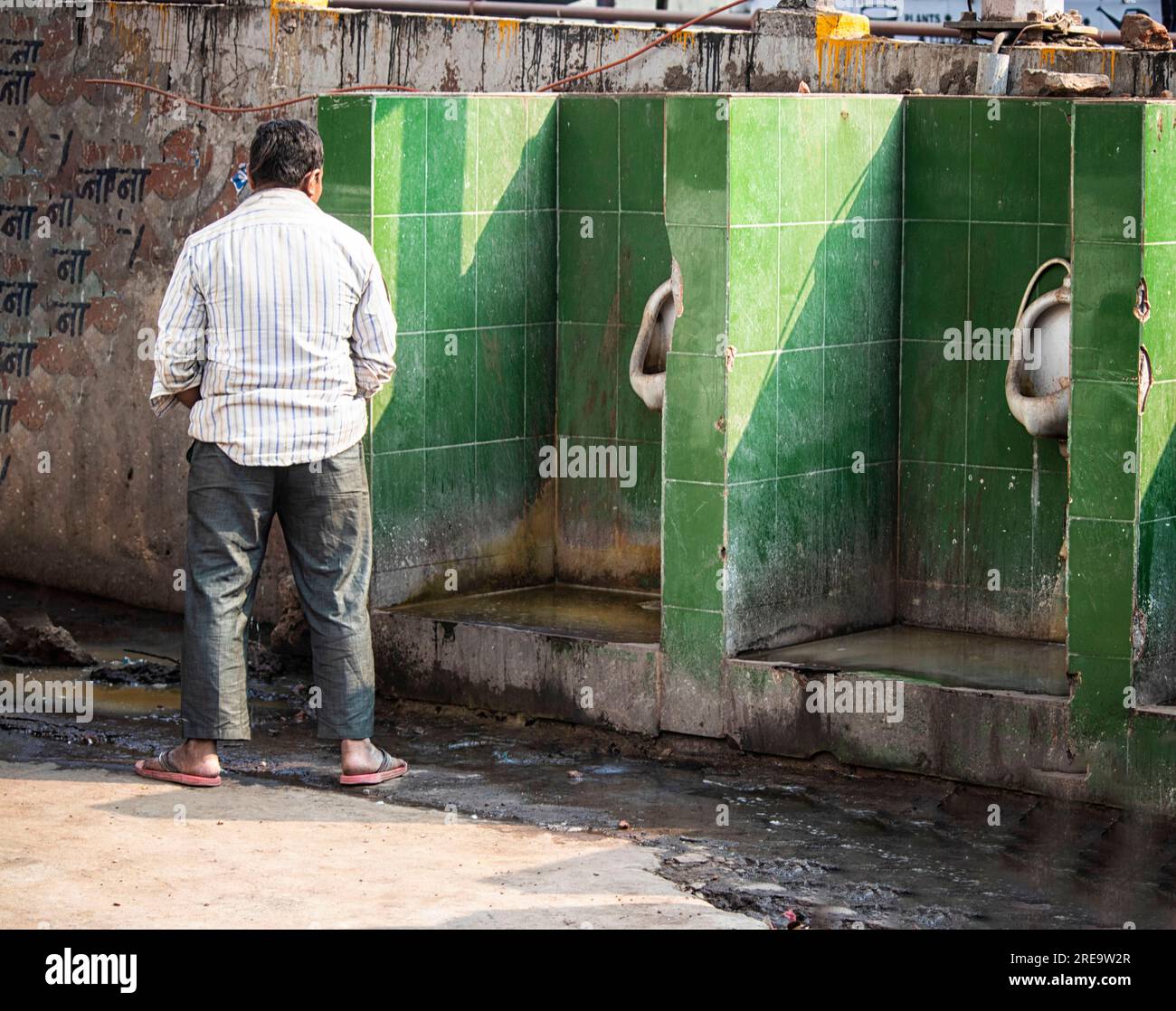Men appear not to be happy with the urinals as they urinate in front of ...
