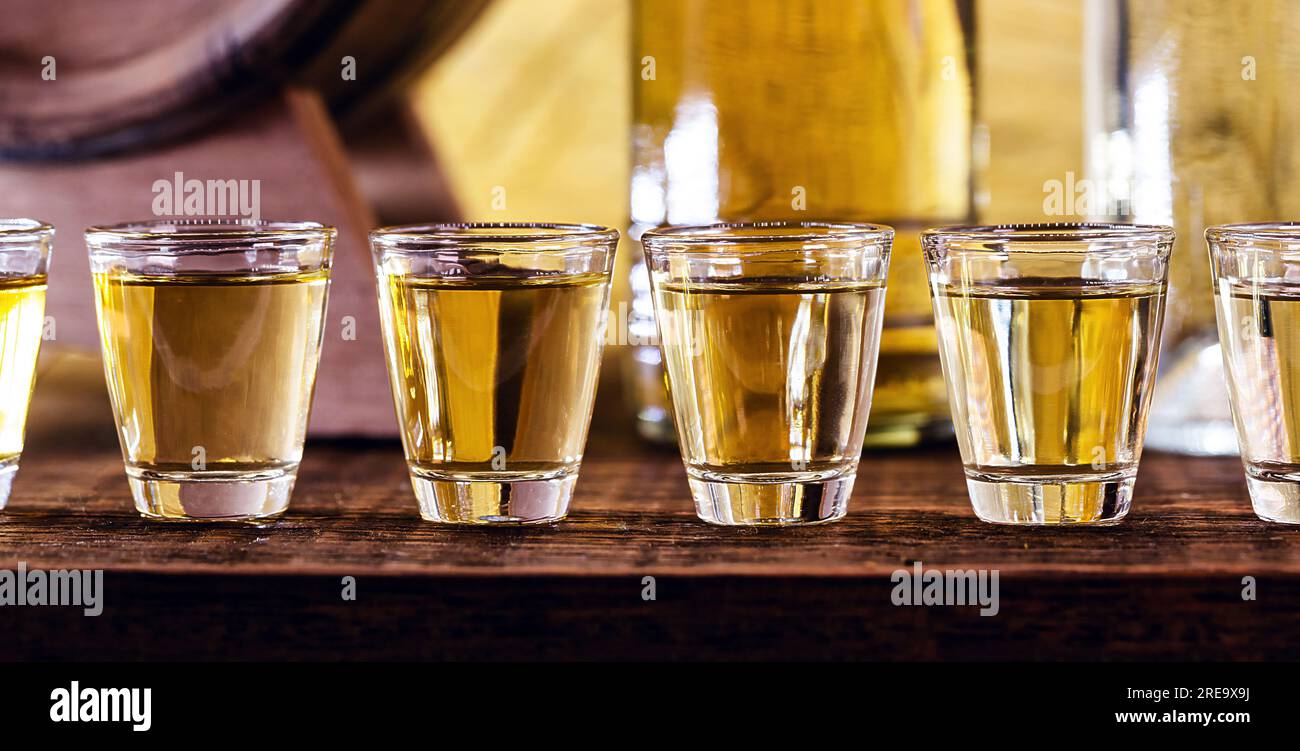 Hand holding glass of alcoholic drinks, cachaça, drips, rum and cognac ...