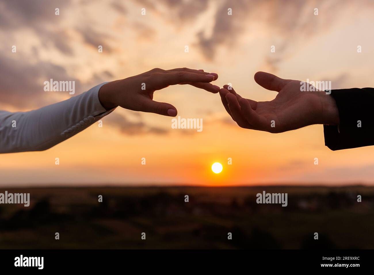 Hands of bride and groom reaching each other, touching fingers on ...