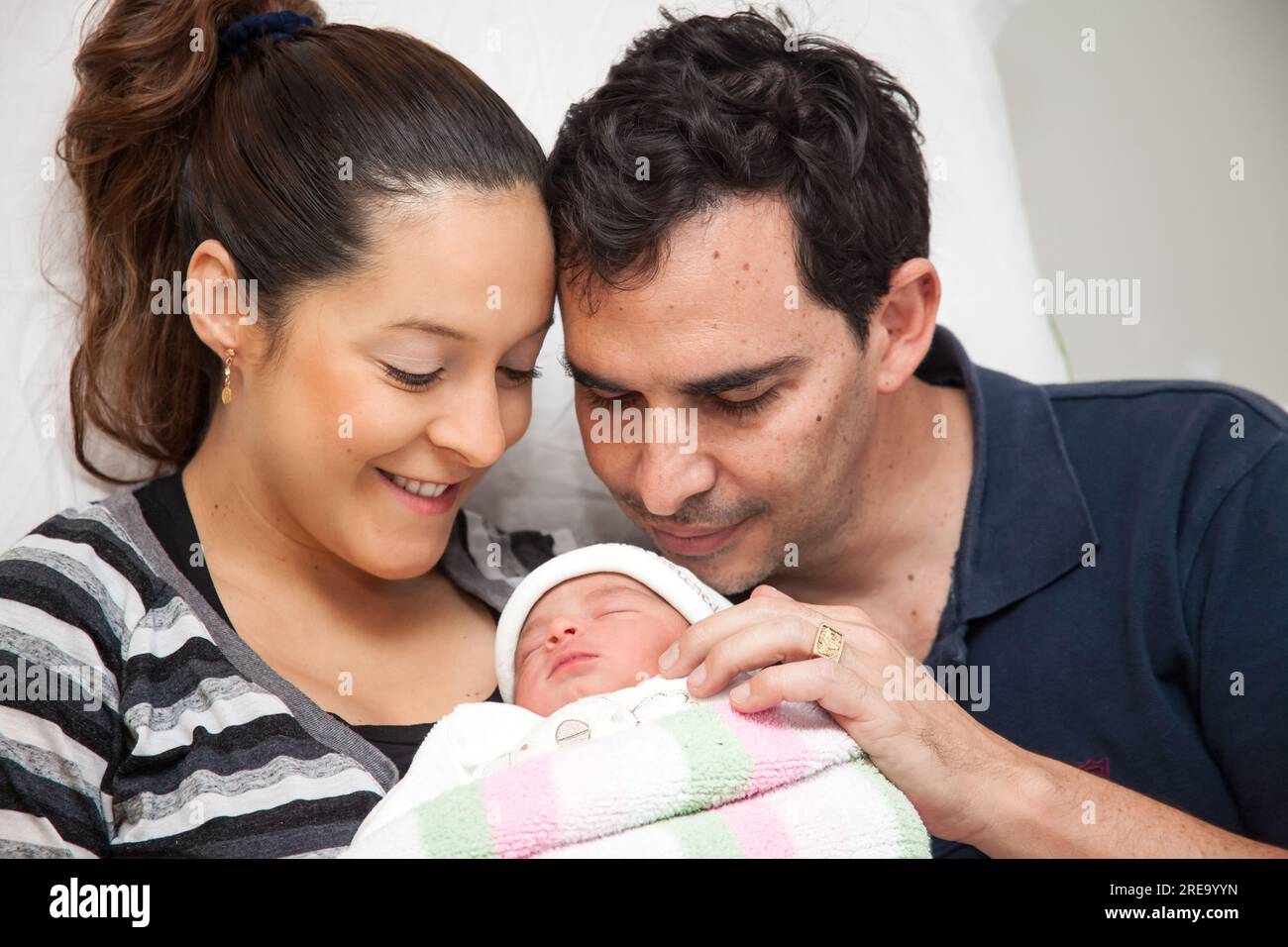 Young mother and father with their newborn baby girl at the hospital on ...