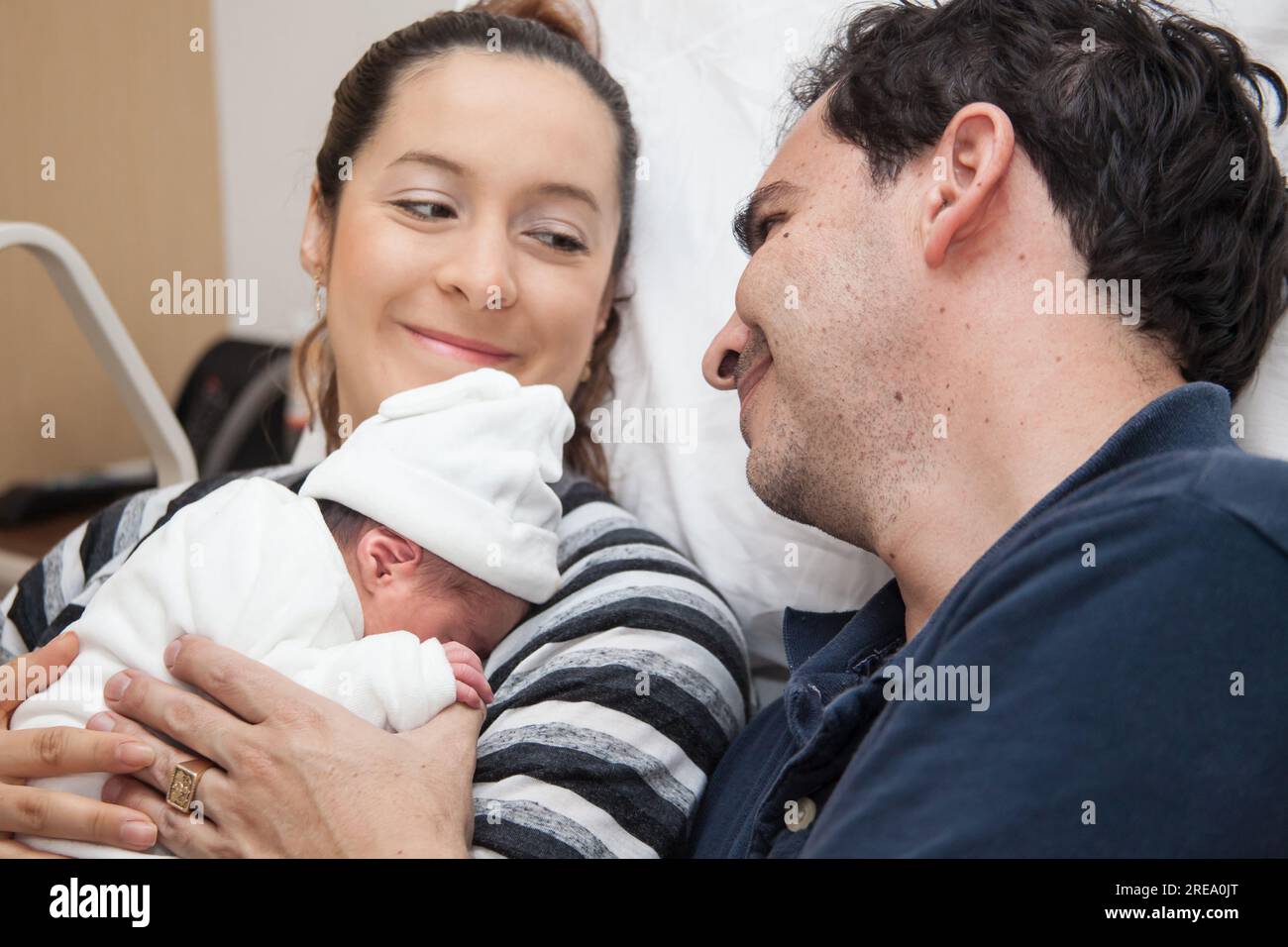Young mother and father with their newborn baby girl at the hospital on ...