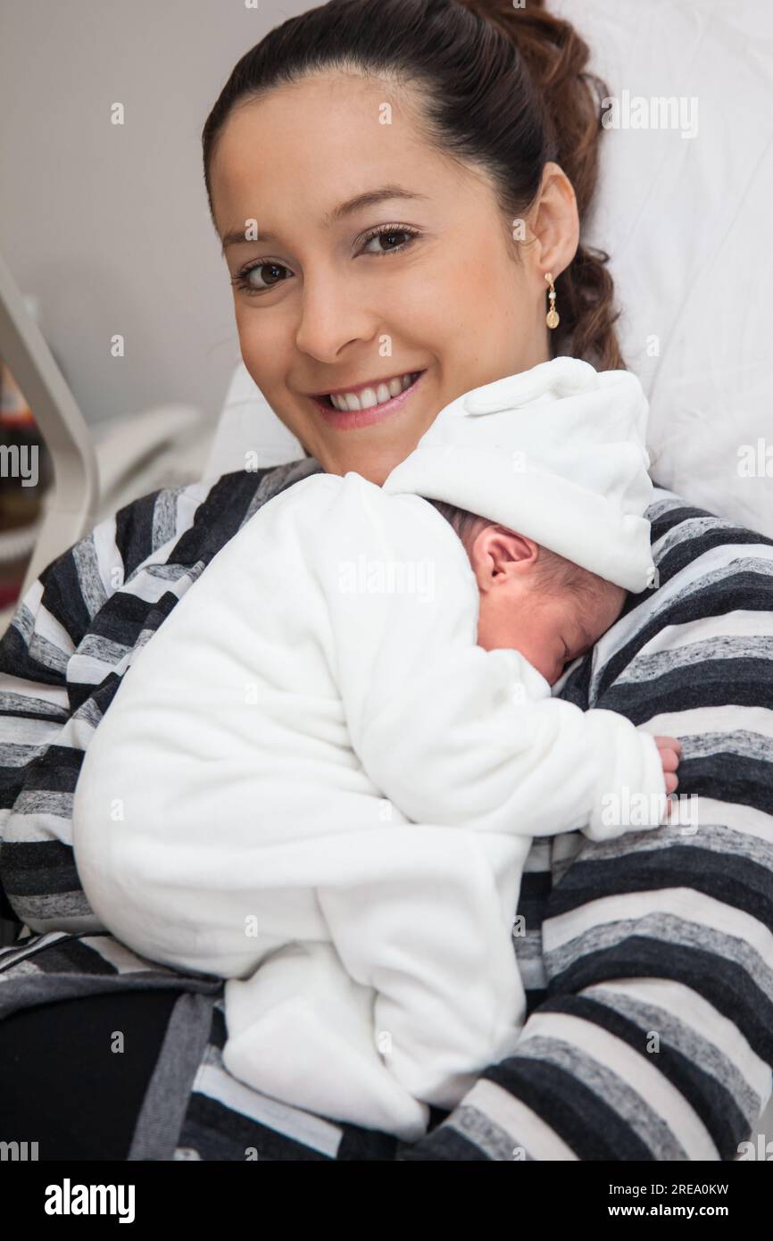 Newborn girl with her mom in the hospital on the day of her birth ...