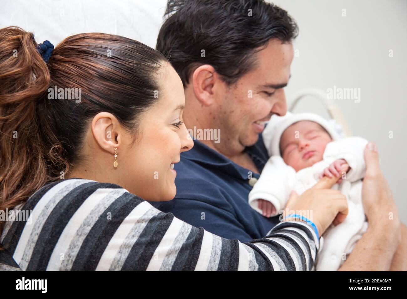 Young mother and father with their newborn baby girl at the hospital on ...