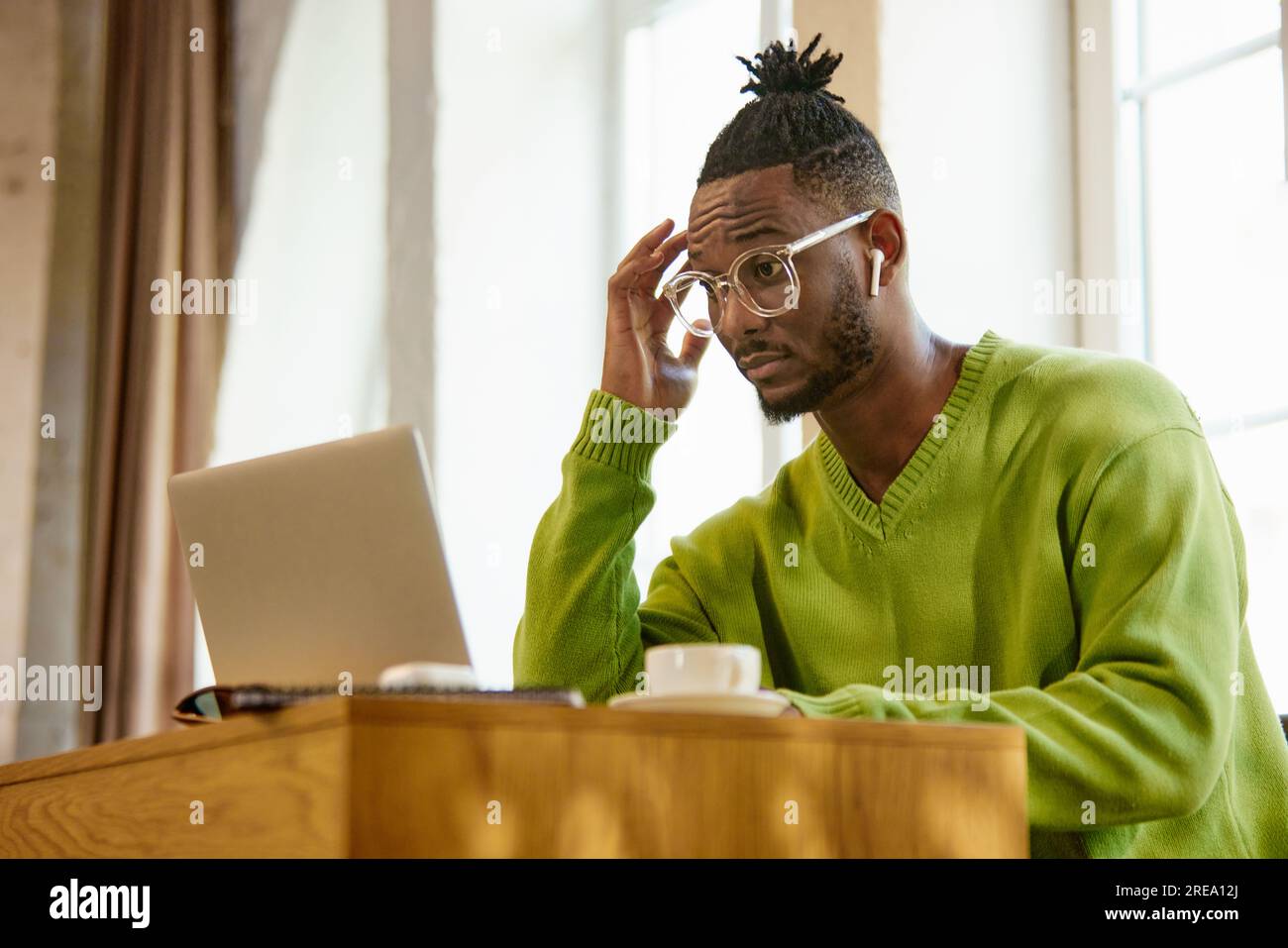Difficult tasks. Young african man, employee working remotely at home ...