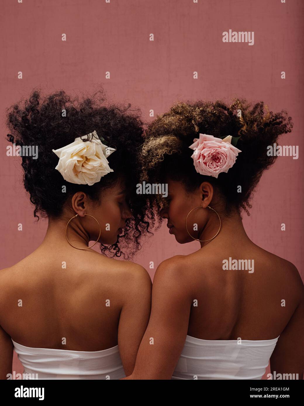 Two females with flowers in their heads standing head to head with ...