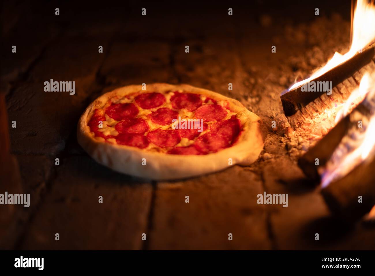Italian pizza pepperoni is cooked in a wood-fired oven. Pizza with ...