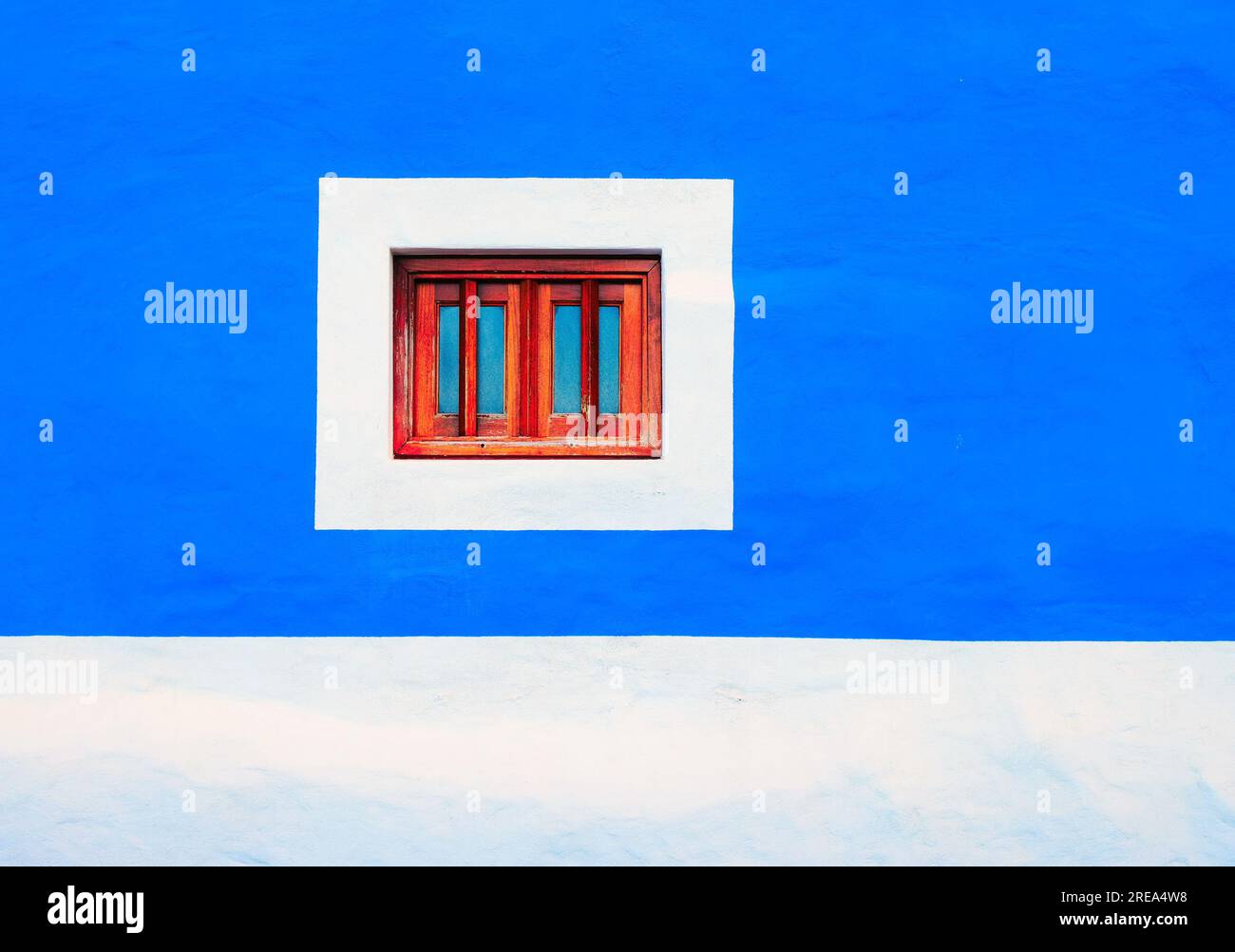 Small wooden window in a large blue wall, architecture design with copy ...