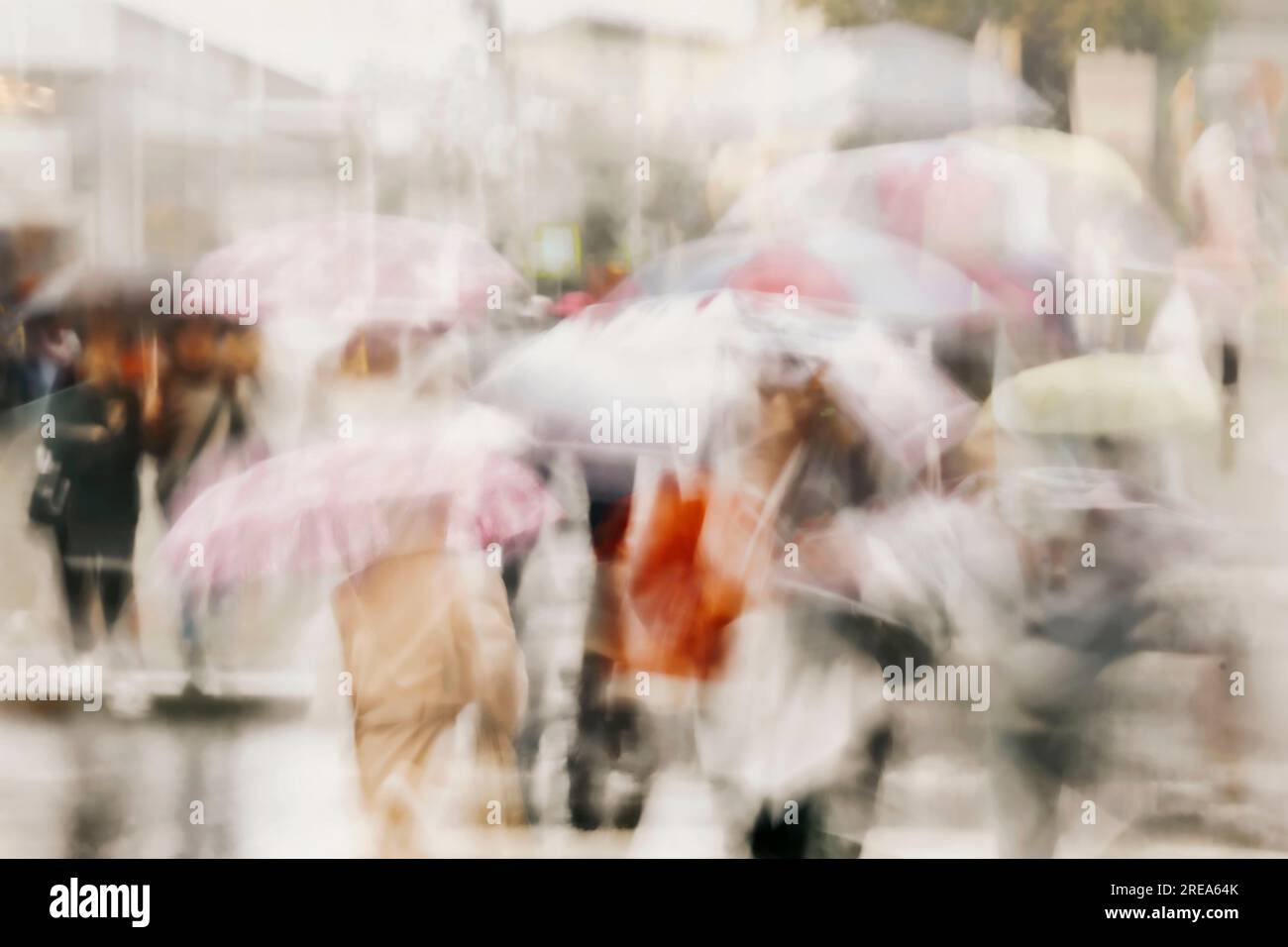 Heavy rain, people holding umbrellas in busy shopping street, blurred ...