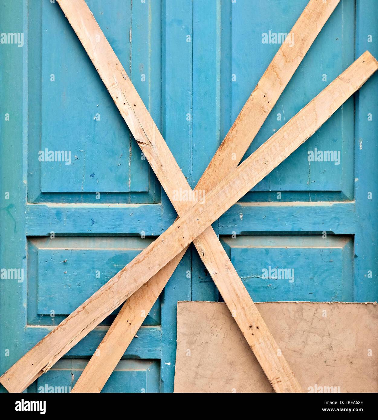 Door to an old house barred and locked with wooden slats nailed down. An old home entrance ...