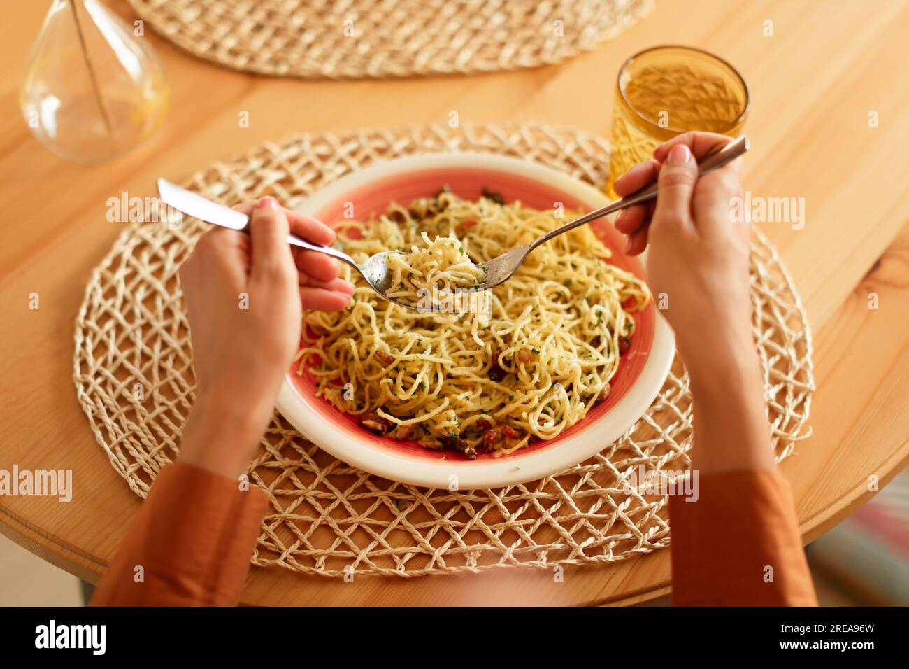 Lady eating tasty Italian pasta with parmesan cheese, holding fork and ...