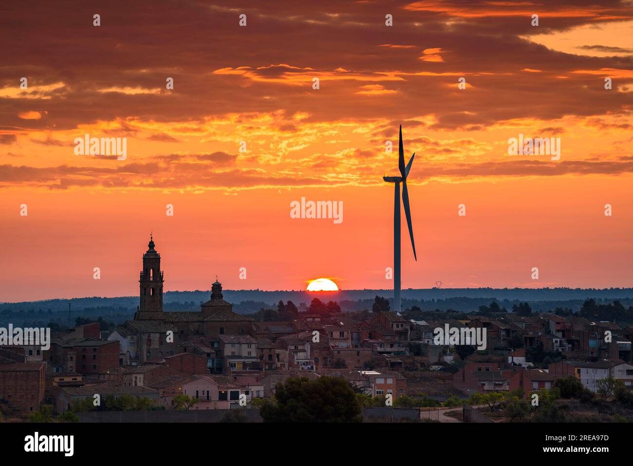 Sunrise over the village of Garriguella and the wind turbines that ...