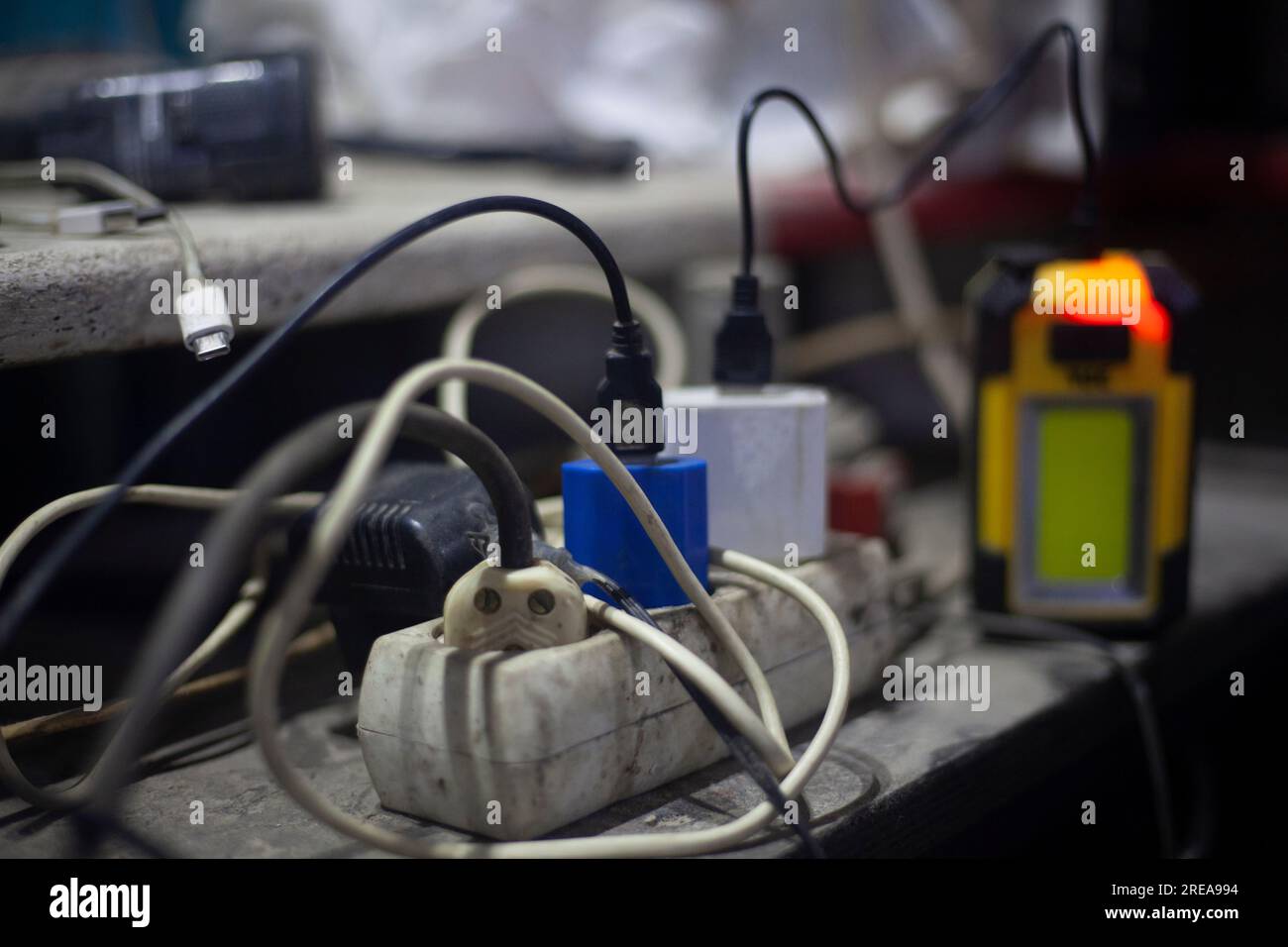 The charger is plugged in. Entangled wires from sockets of various ...