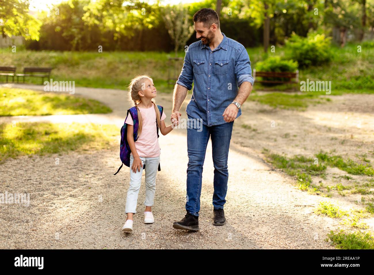 Parent and primary school pupil. Father accompanies the child girl to ...