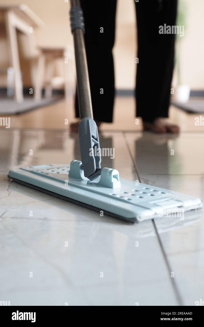 cleaning tiles floor with mop Stock Photo - Alamy