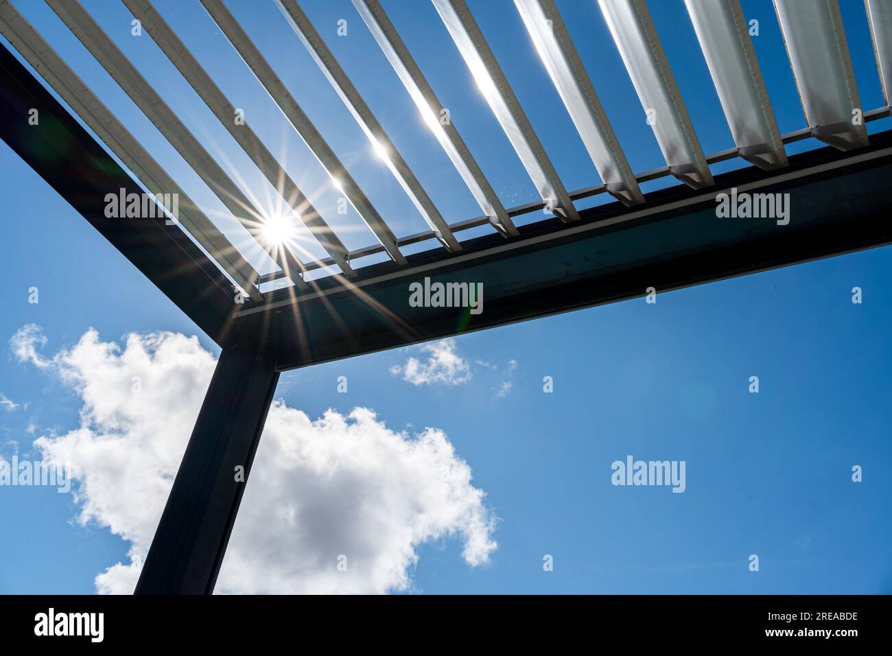 Trendy outdoor patio pergola. the sun's rays pass through the metallic ...