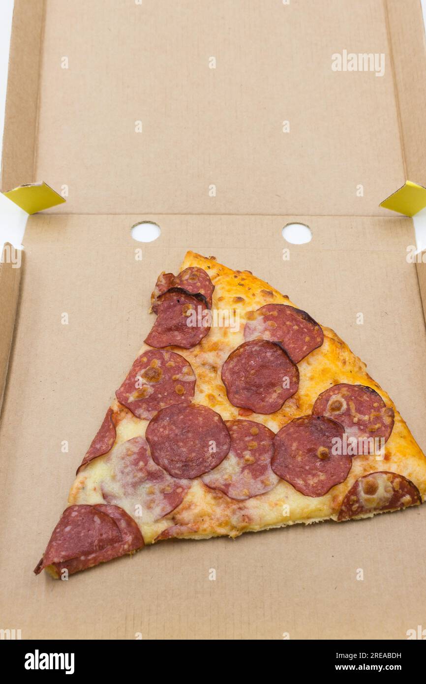 slice of hot fresh appetizing pizza lies in a cardboard box Stock Photo ...
