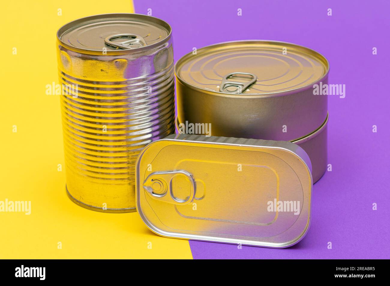 A Group of Stacked Tin Cans with Blank Edges on Split Yellow and Violet ...
