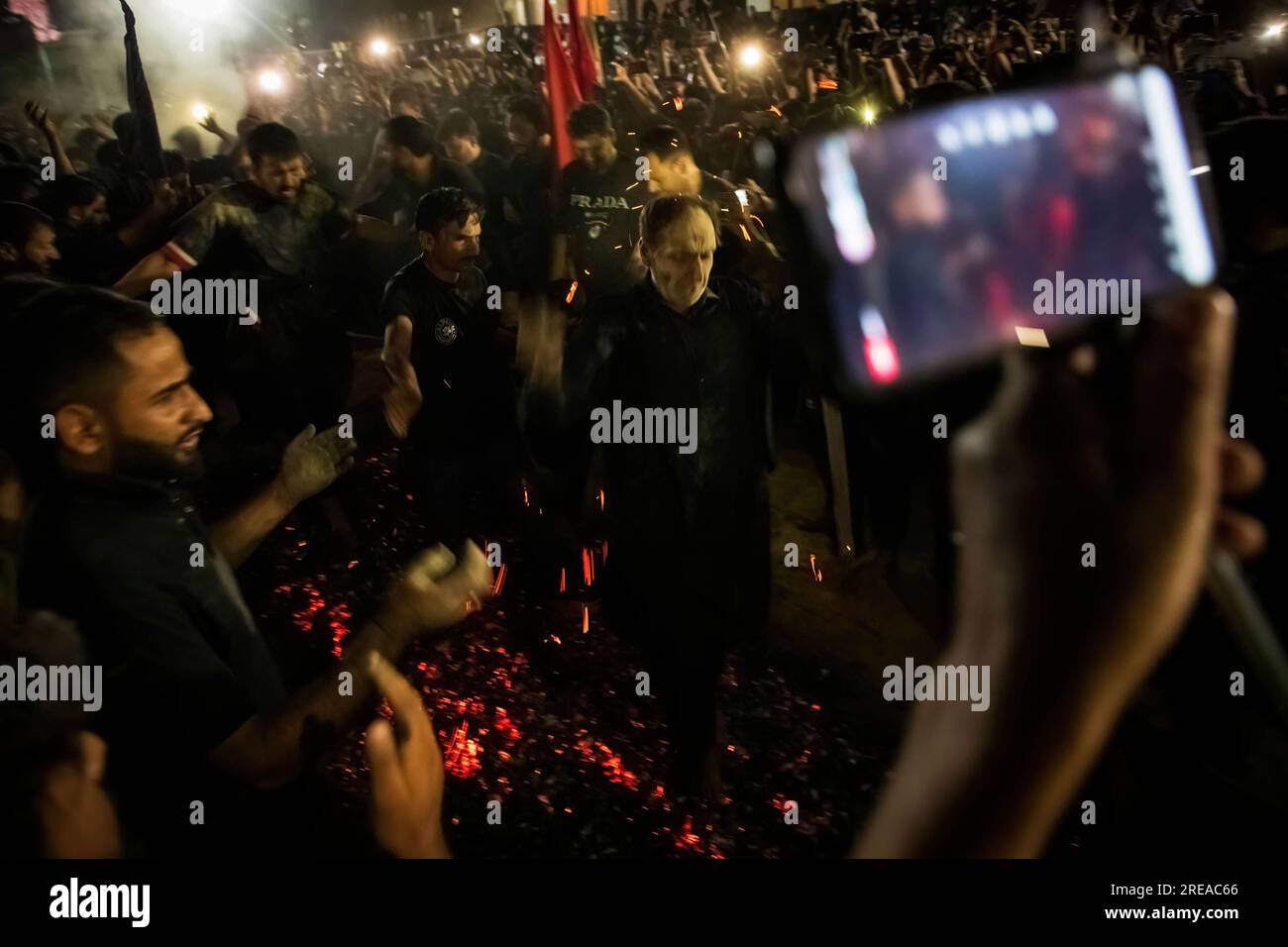 Kashmiri Shiite Muslim men walk barefoot across a fire pit during the ...