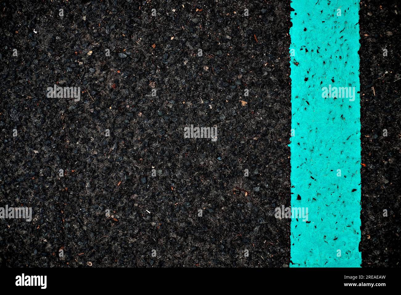 Wide light blue vertical stripe painted on black tarmac surface Stock ...