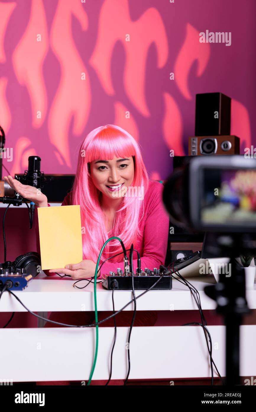 Asian content creator showing notebook advertising school supplies in ...