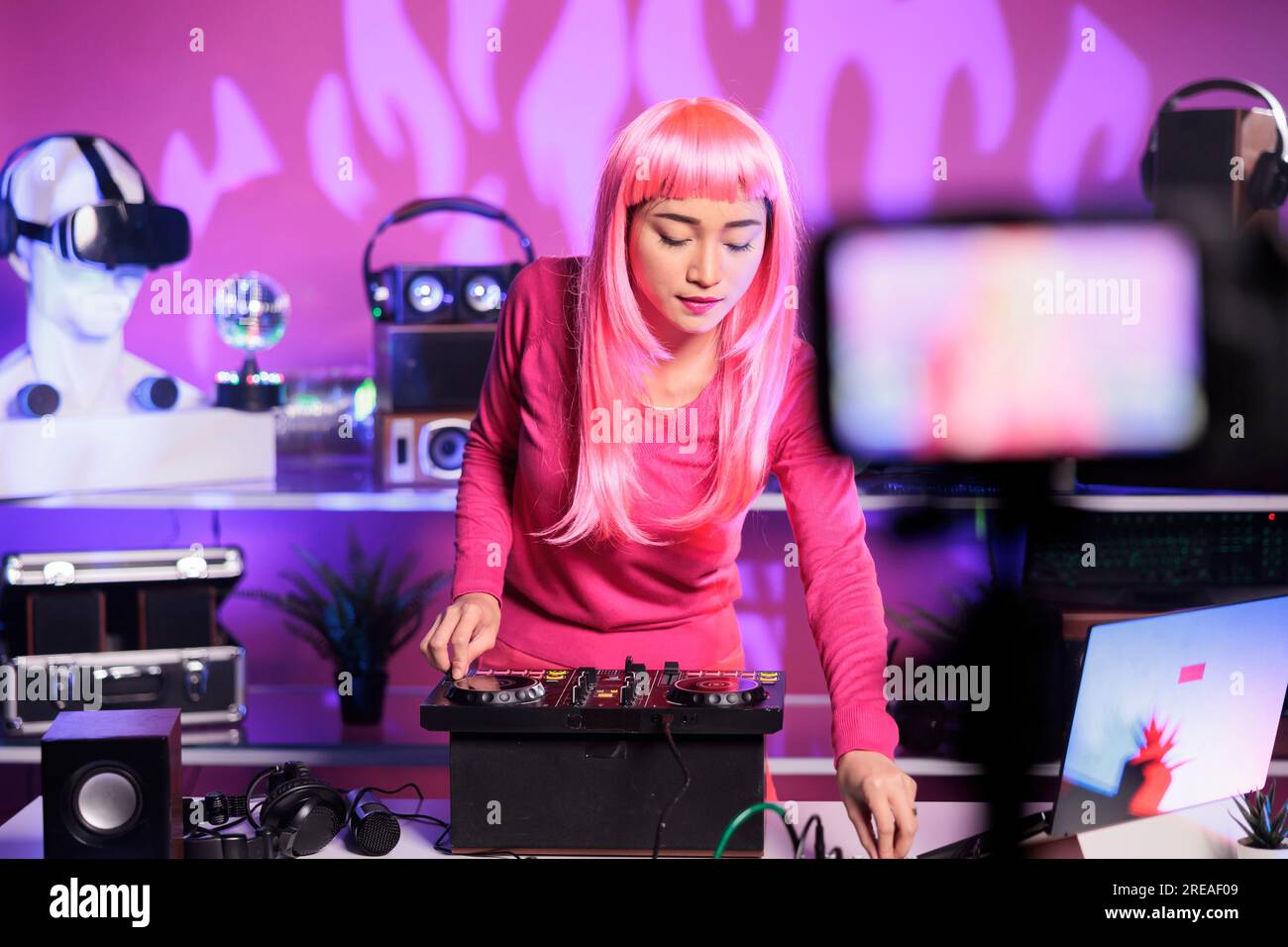 Smiling woman mixing techno music at professional mixer console having ...
