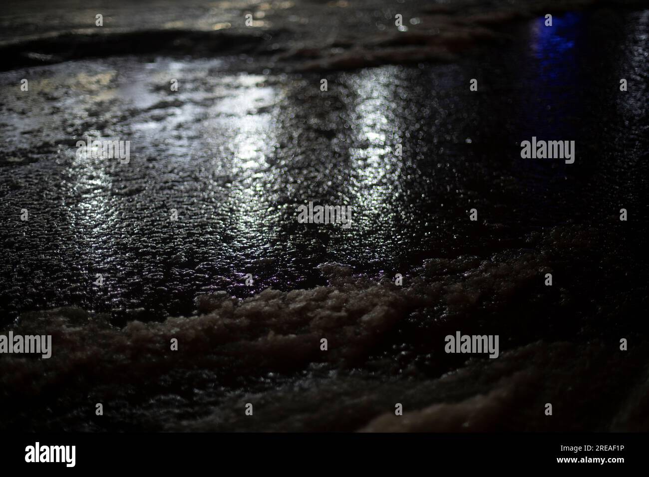 Big puddle in road. Puddle in front of shop. Frozen surface. Melting ...