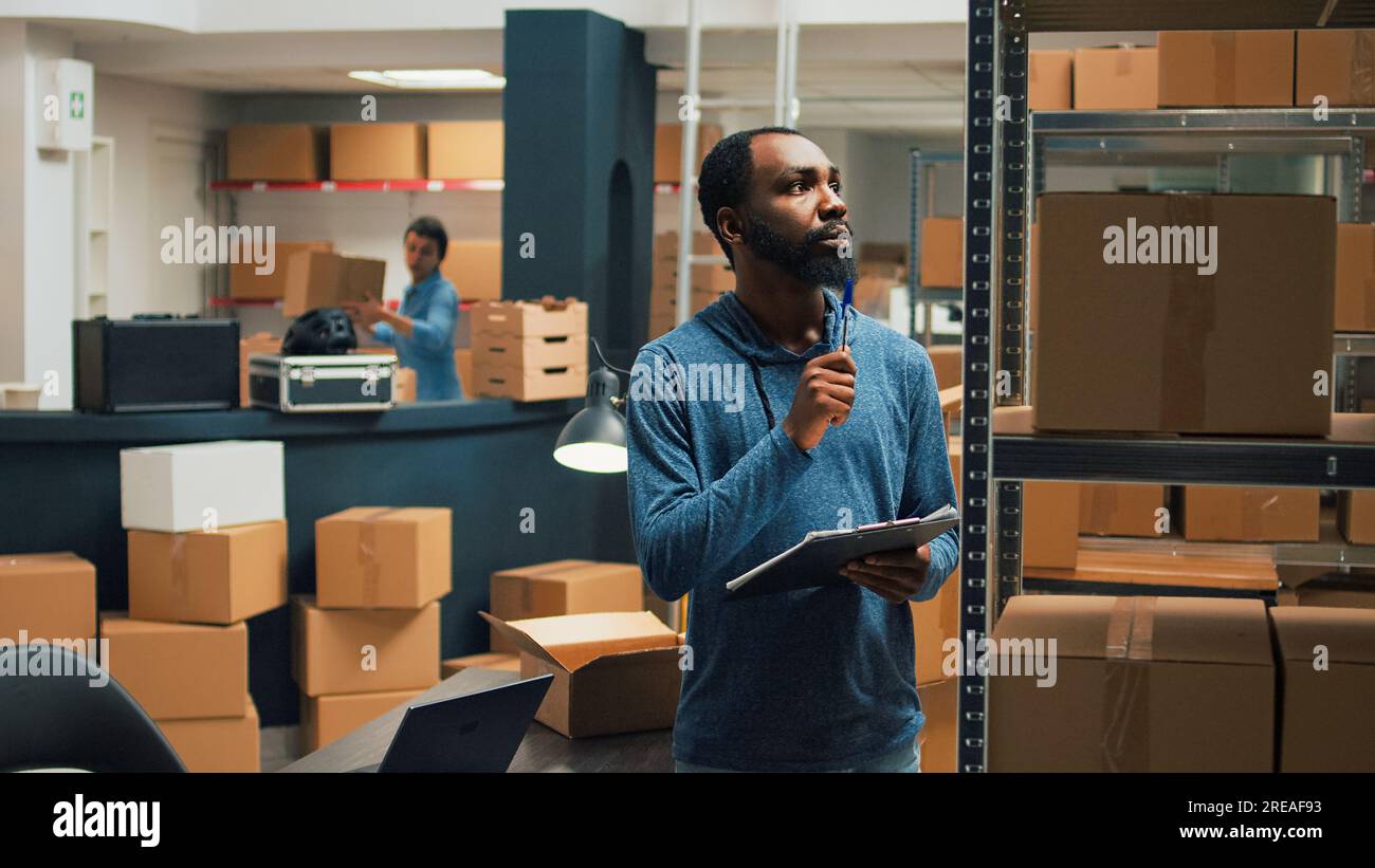 African american employee taking inventory notes on clipboard papers ...