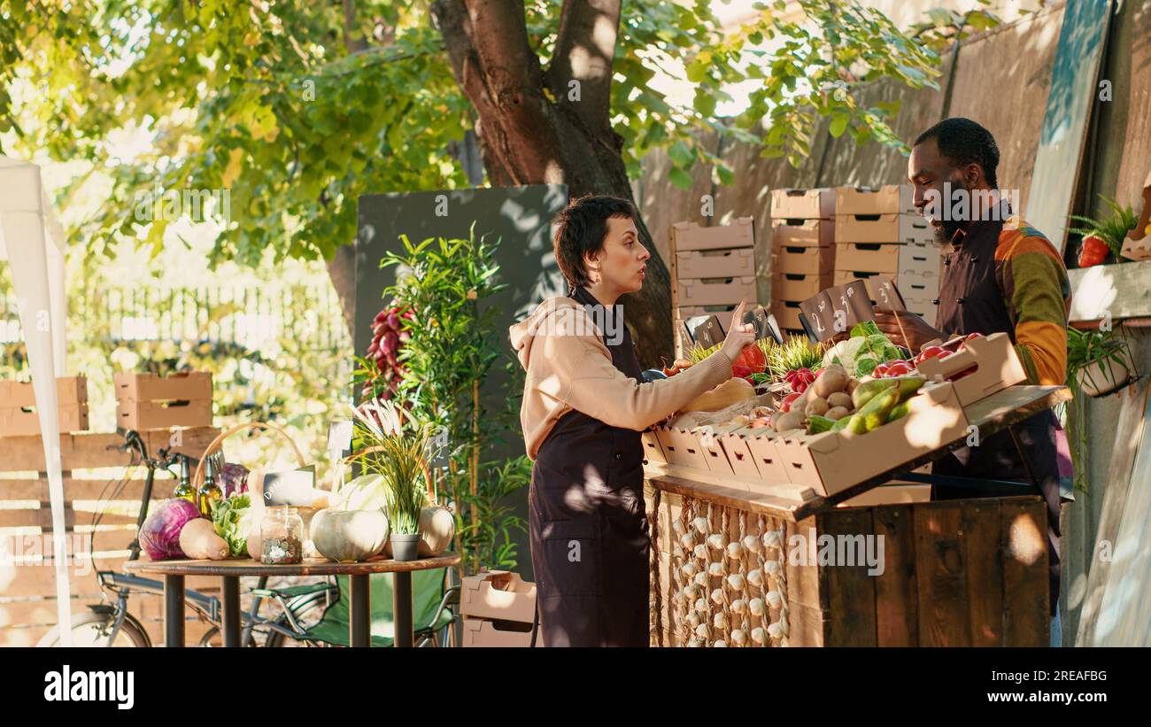 Team of diverse sellers giving box with natural fruits and veggies to ...