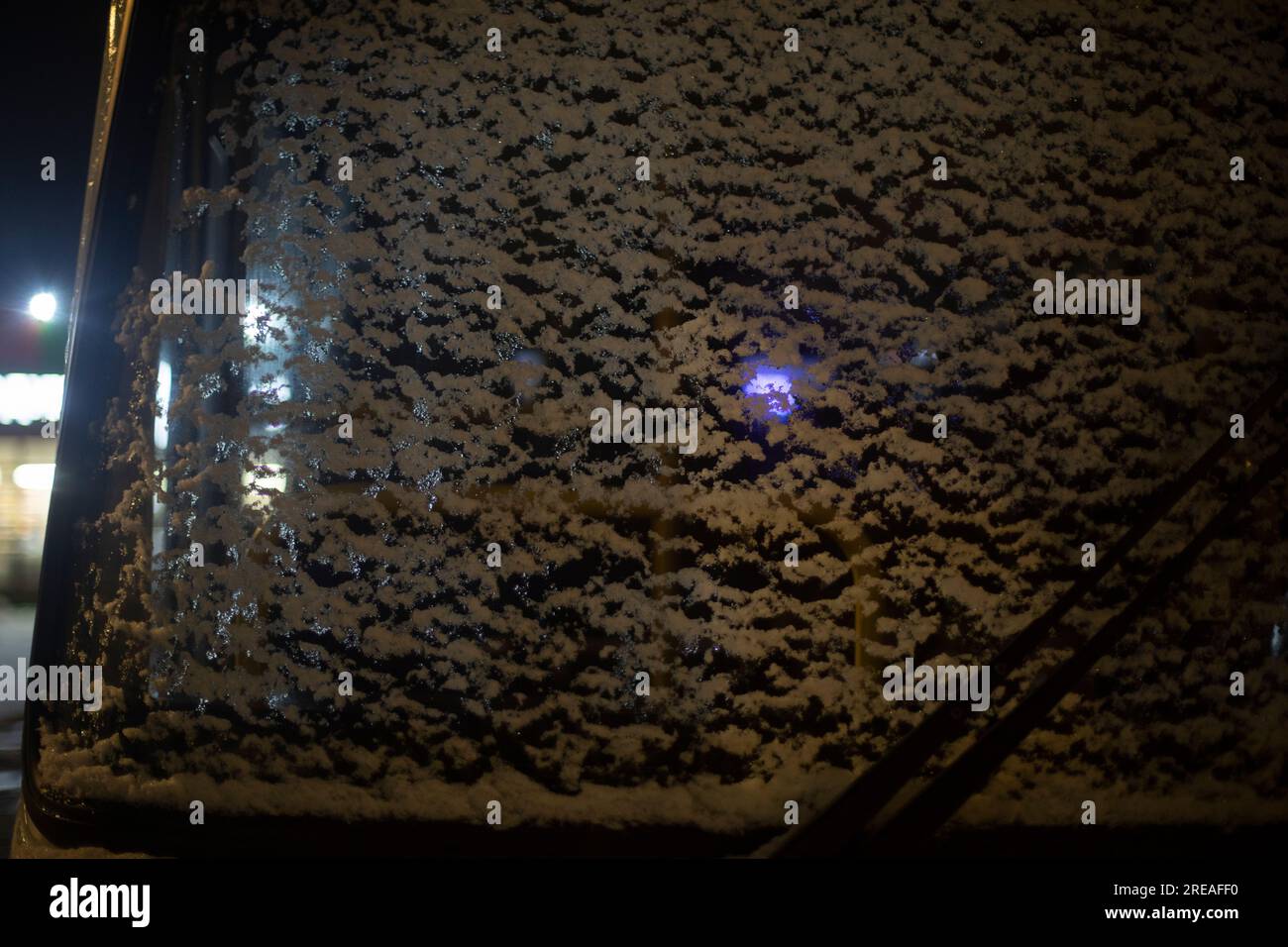 Snow on glass of bus. Transport at night in parking lot in detail ...