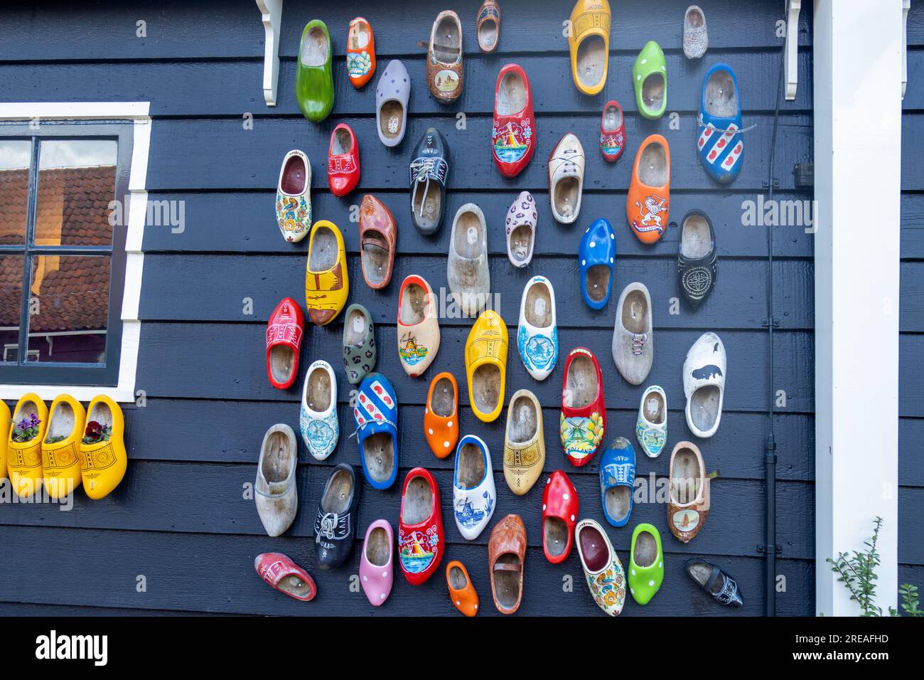 Very colourful traditional dutch wooden clogs on the side of a blue ...
