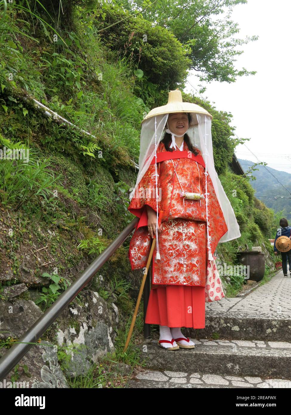 A young woman in traditional costume stands on the stone steps at the ...
