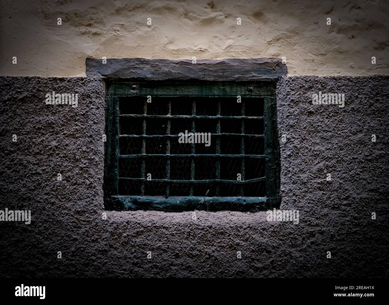 Dark barred prison window in a jail wall, dark and oppresive ...