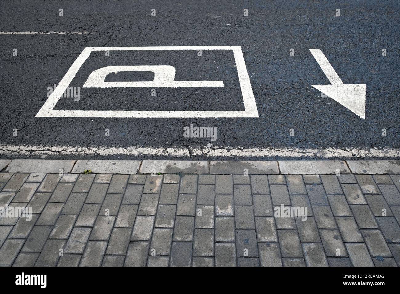 Large white car parking sign painted on black tarmac pavement and a big ...