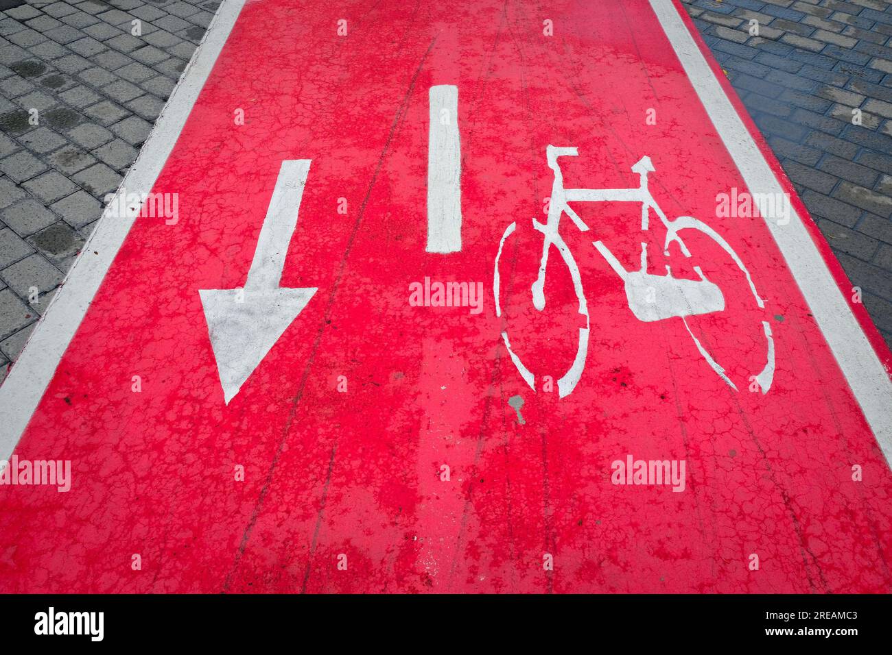 City biking road painted red with white bike symbol and a traffic lane ...