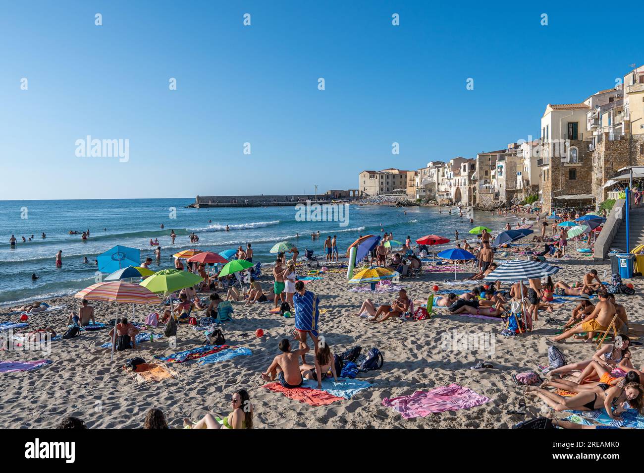The beach and Old Town in Cefalù on a late afternoon in July. Historic ...