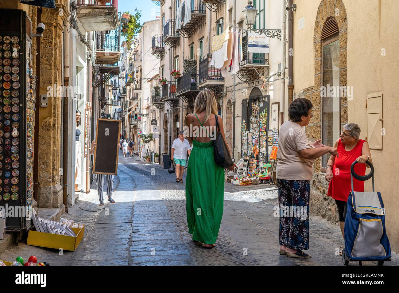 Elerly ladies chat in the Old Town of Cefalú. This historic town is a ...