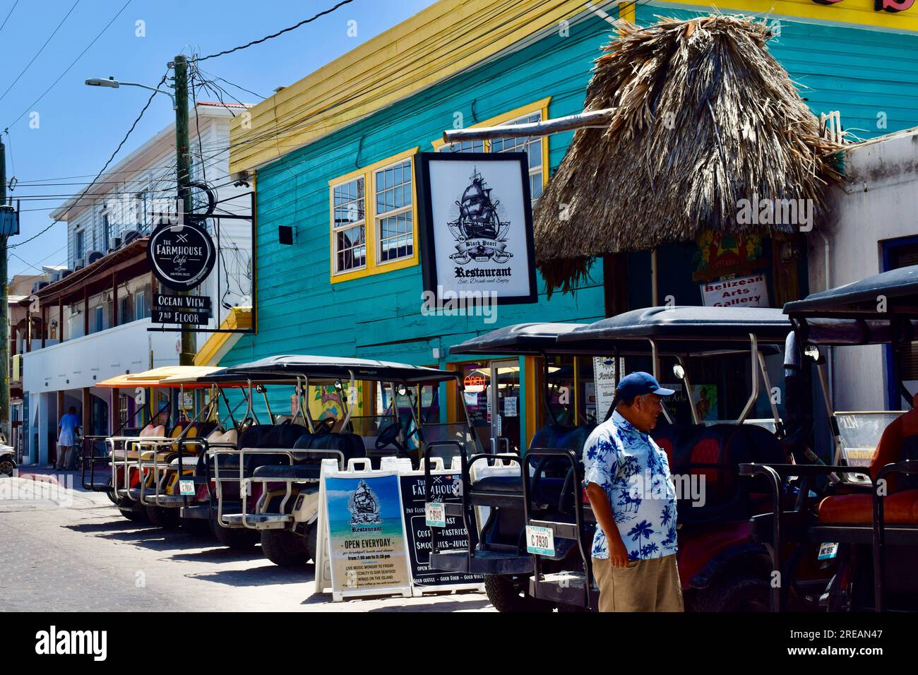 Front Street in San Pedro Town, with golf carts, shops, restaurants ...