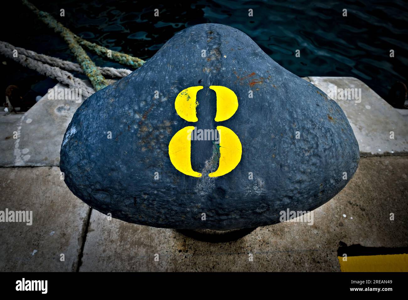 Number 8, eight, a yellow digit on a black harbor bollard Stock Photo ...