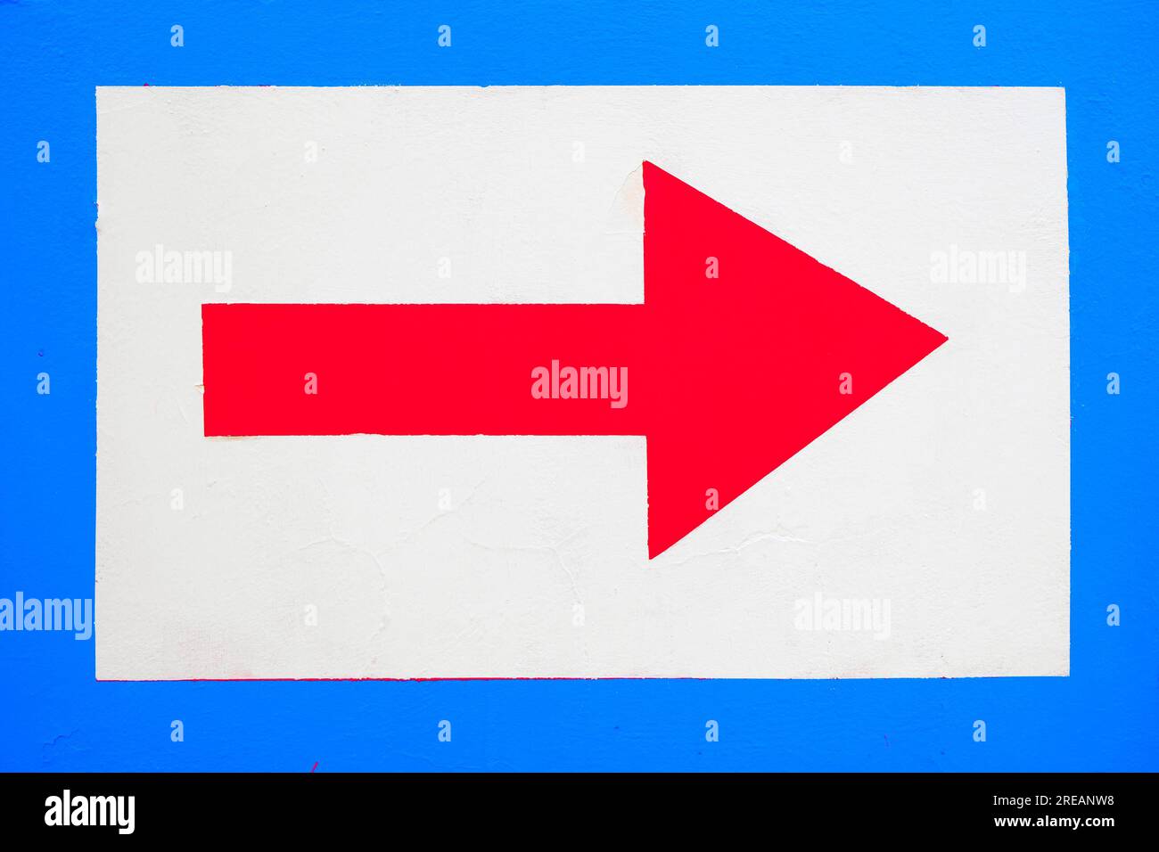 A single bold red arrow painted on a white background with a blue frame ...