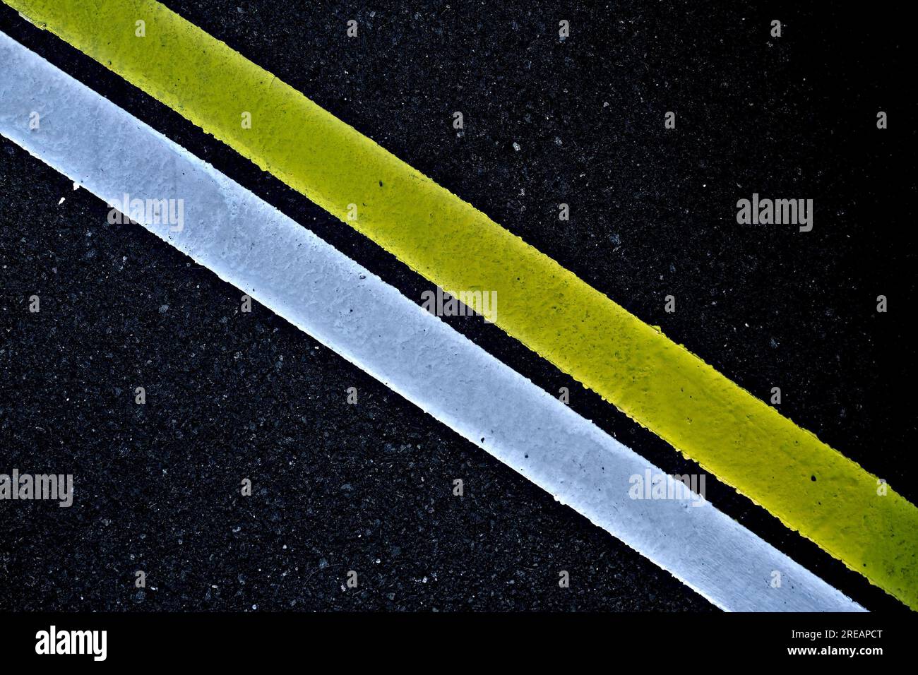 Yellow and white wide bands painted with luminescent road marking paint ...