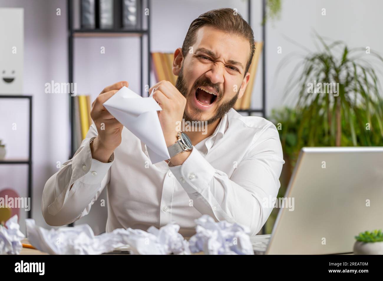 Angry furious businessman working at office throwing crumpled paper ...
