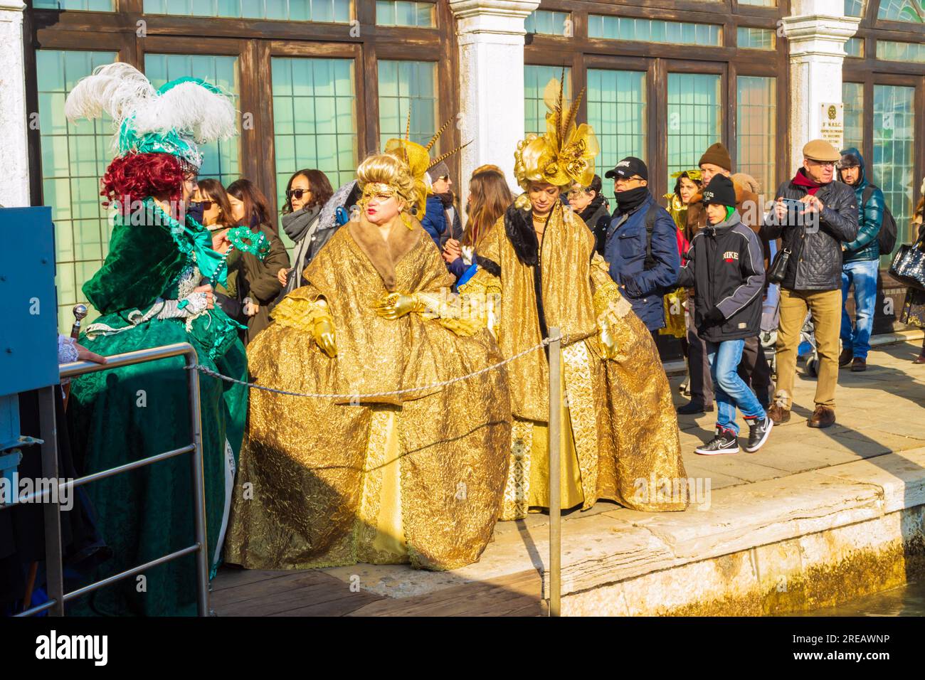 :tourists and masqued people tour on quayside in Venice,Italy at the ...