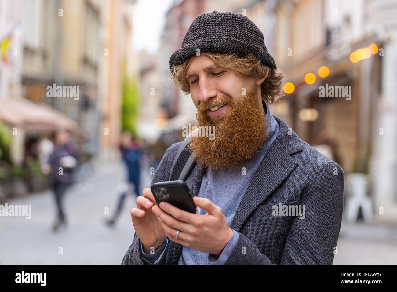 Portrait of young adult man using smartphone typing text messages ...