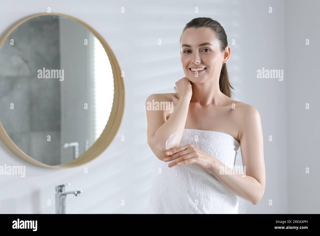 Woman applying lotion elbow in hi-res stock photography and images - Alamy