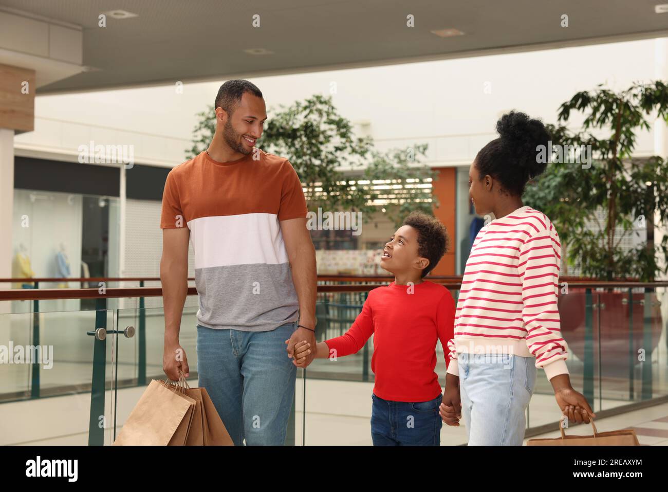 Family shopping. Happy parents and son with purchases in mall Stock ...