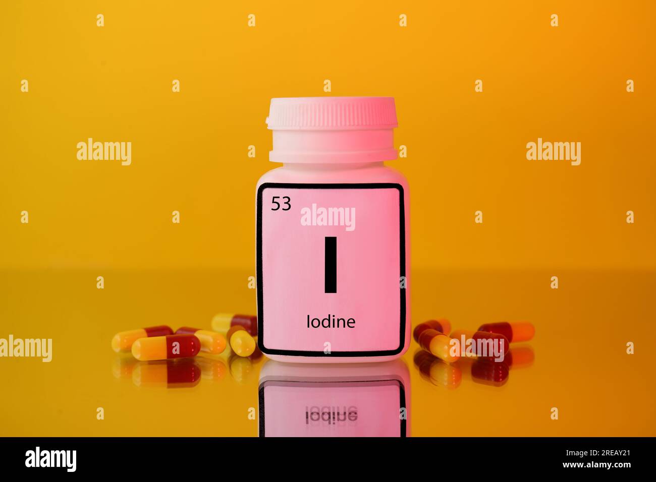 Bottle of medical iodine and pills on yellow background, color tone ...
