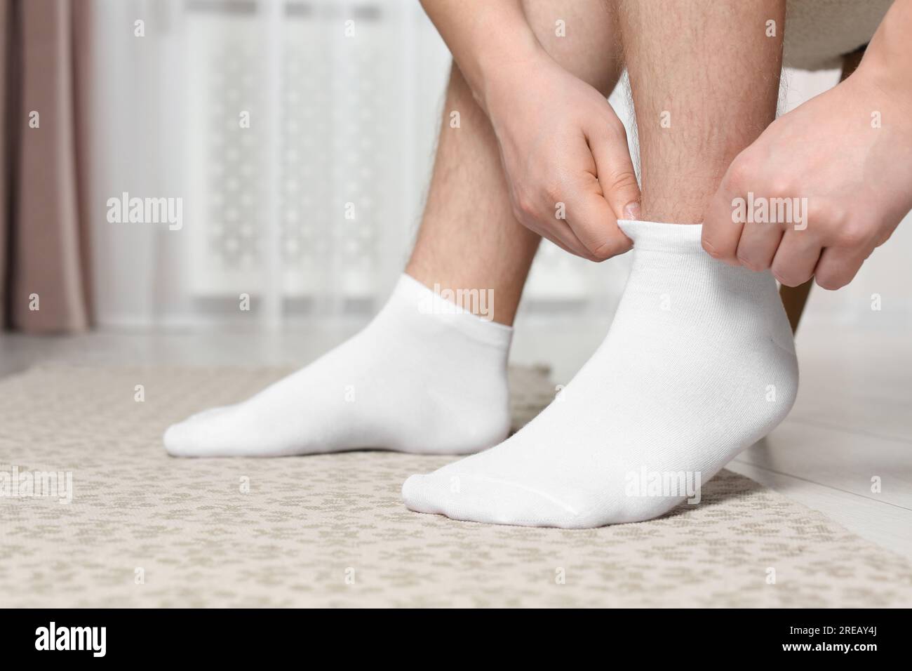 Man putting on white socks at home, closeup Stock Photo - Alamy
