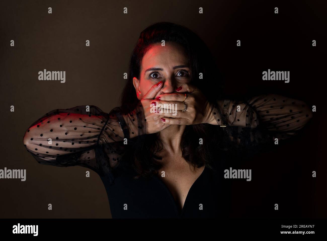 Coaching woman in black clothing with hands covering her mouth in a ...